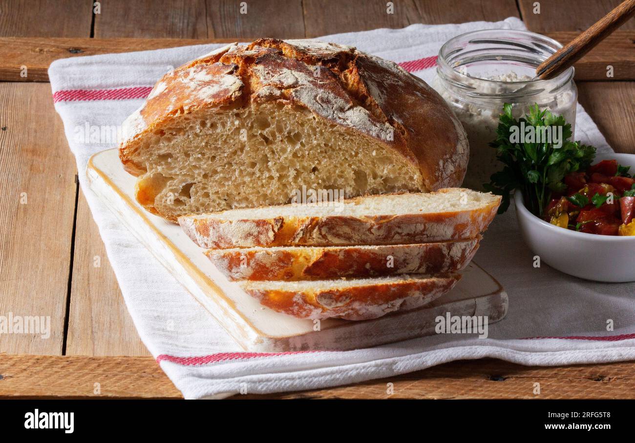 Round yeast bread made from white and whole grain flour, tomato salad ...
