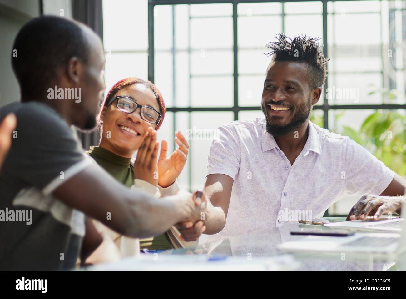 Smiling african american man shaking hands with a business partner at a ...