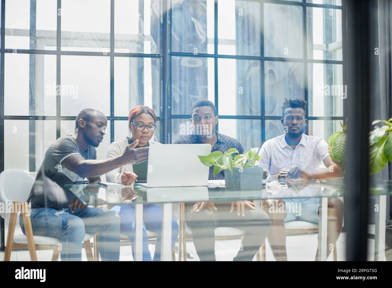 ehind the glass view of executives discussing project in modern office ...