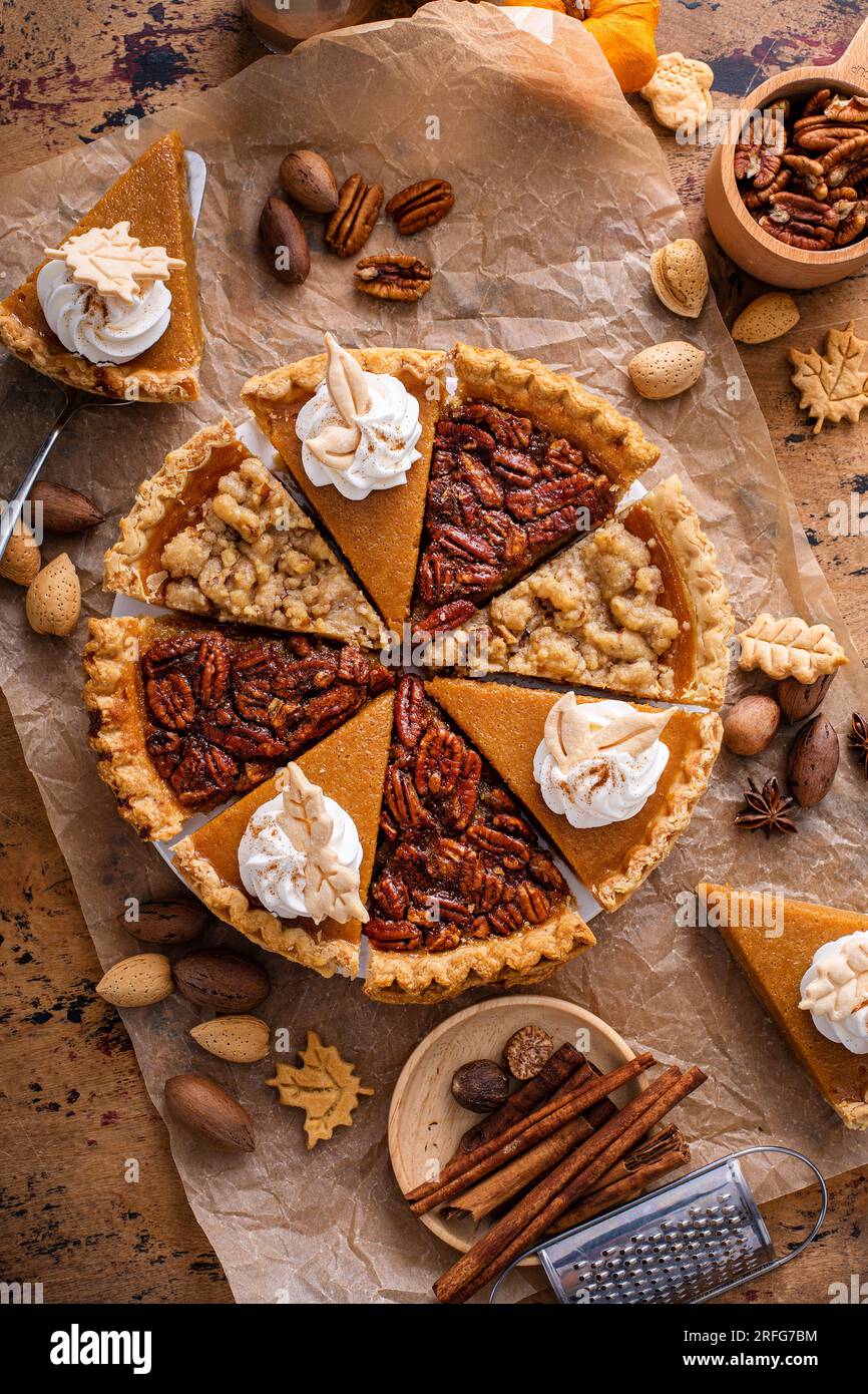 Thanksgiving pies slices on parchment paper, pumpkin and pecan pie ...