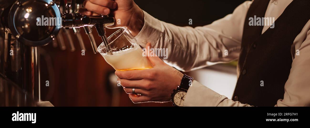 hands of bartender pour into glass draught light foamy beer from tap in bar Stock Photo - Alamy