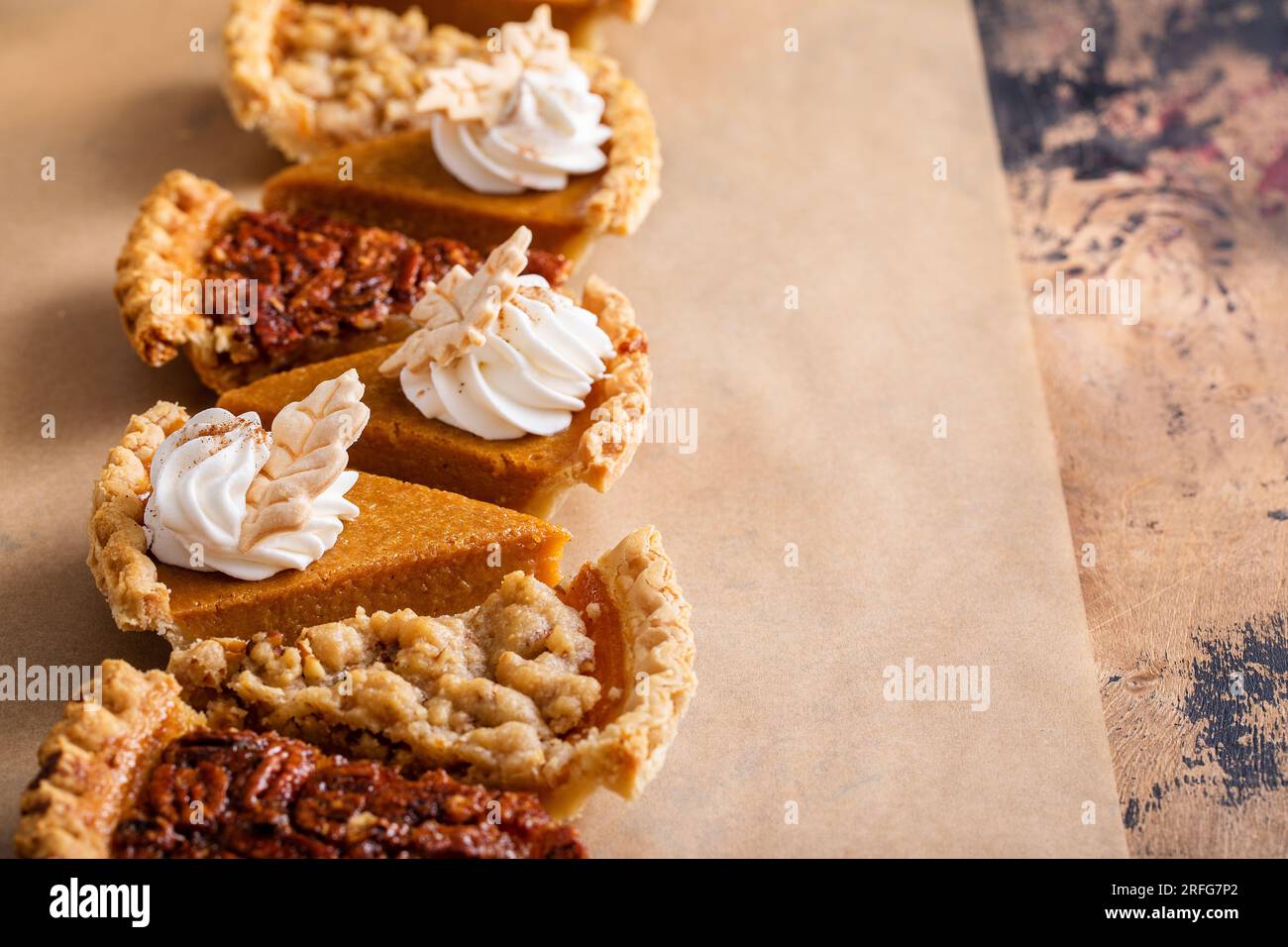 Thanksgiving pies slices on parchment paper, pumpkin and pecan pie ...
