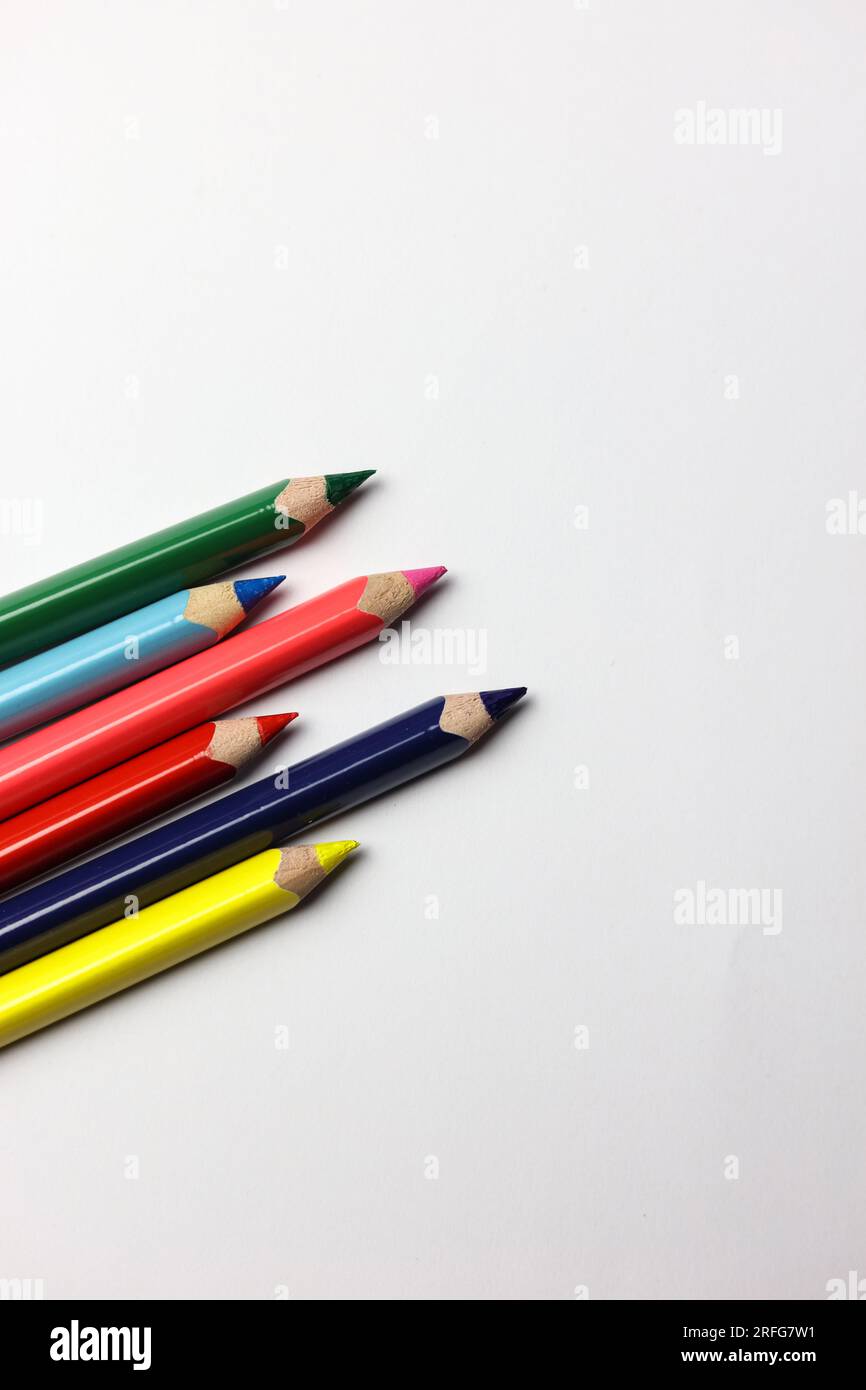 a bunch of multicolored coloring pencils on a white paper background ...