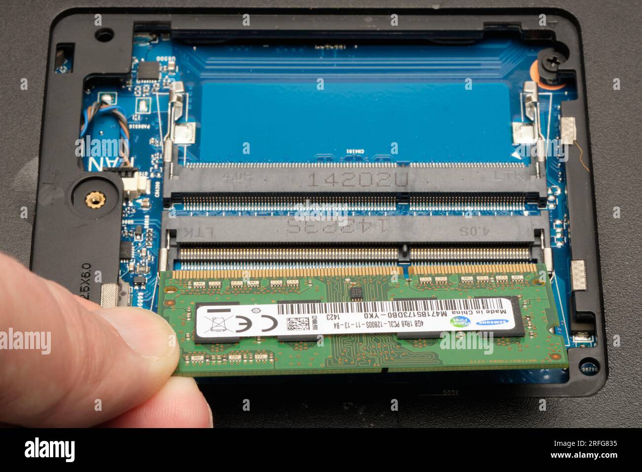 Inserting a typical RAM memory module into a memory socket in a laptop ... Inserting a typical RAM memory module into a memory socket in a laptop ...