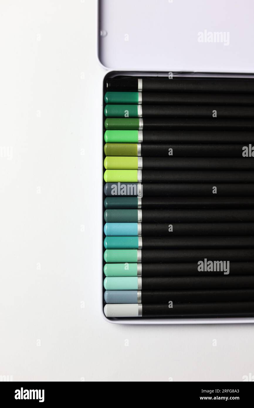 a set of coloring pencils in a white tin box on a white background ...