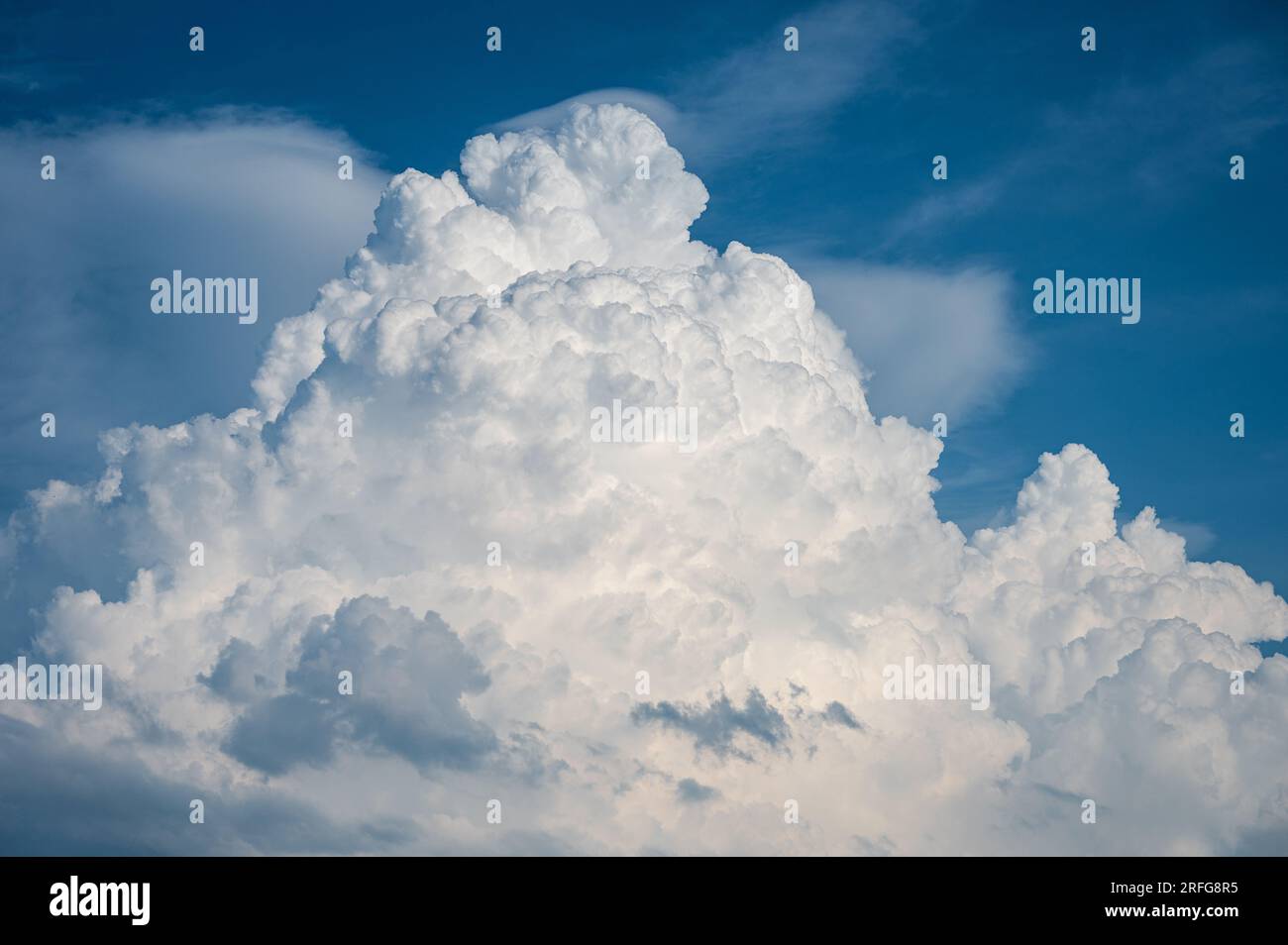 A huge fluffy cloud in the form of a mountain in the blue sky ...