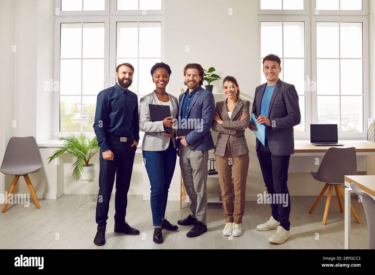 Multi ethnic group of successful confident office workers professional experts stand in row one ...