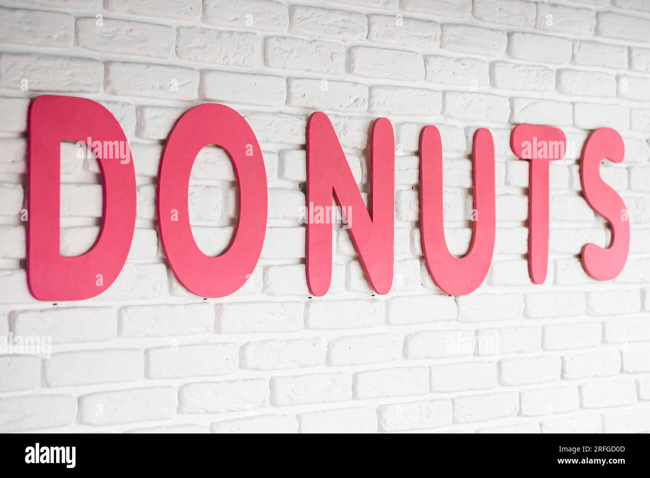 The word donuts on a white wall in a cafe, interior decor in a cafe ...