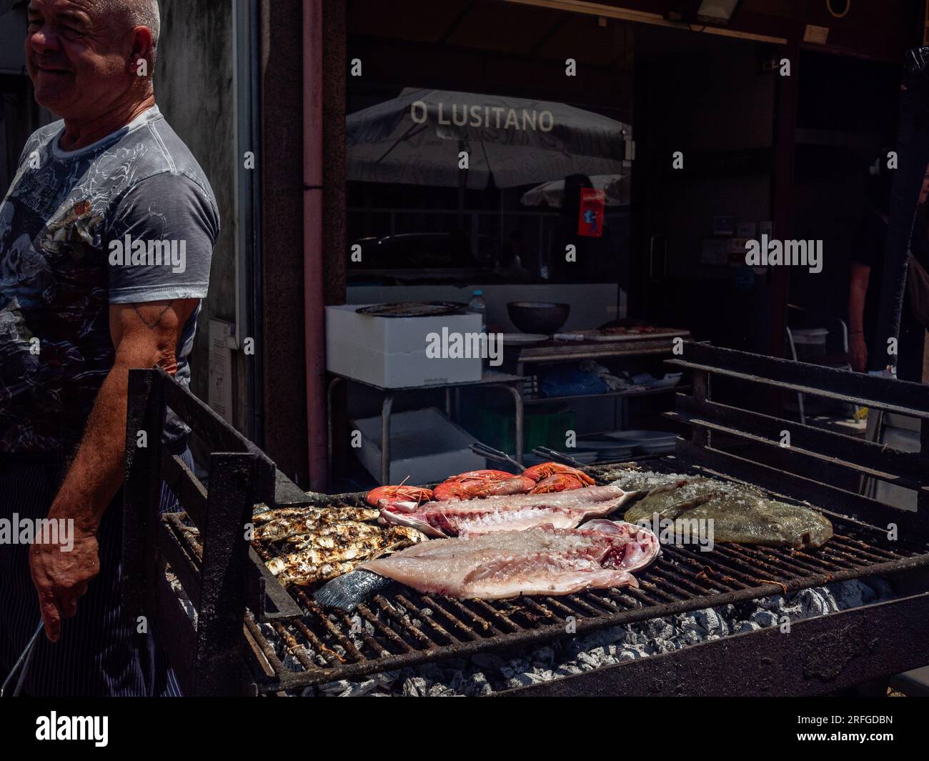 A man is seen grilling typical fish on the street. Over time, the ...