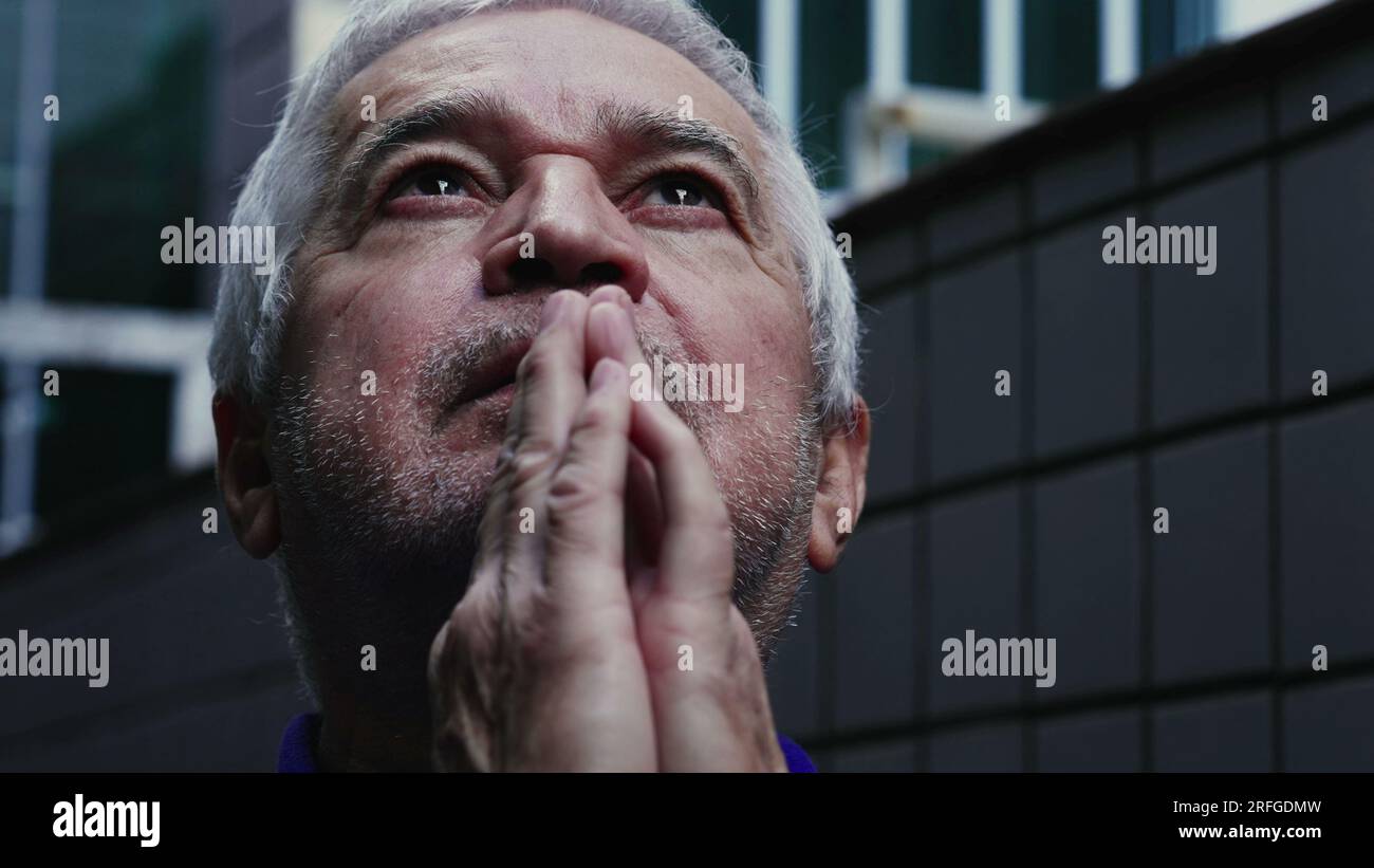 Faithful senior man Praying to GOD looking up closing eyes in HOPE and ...