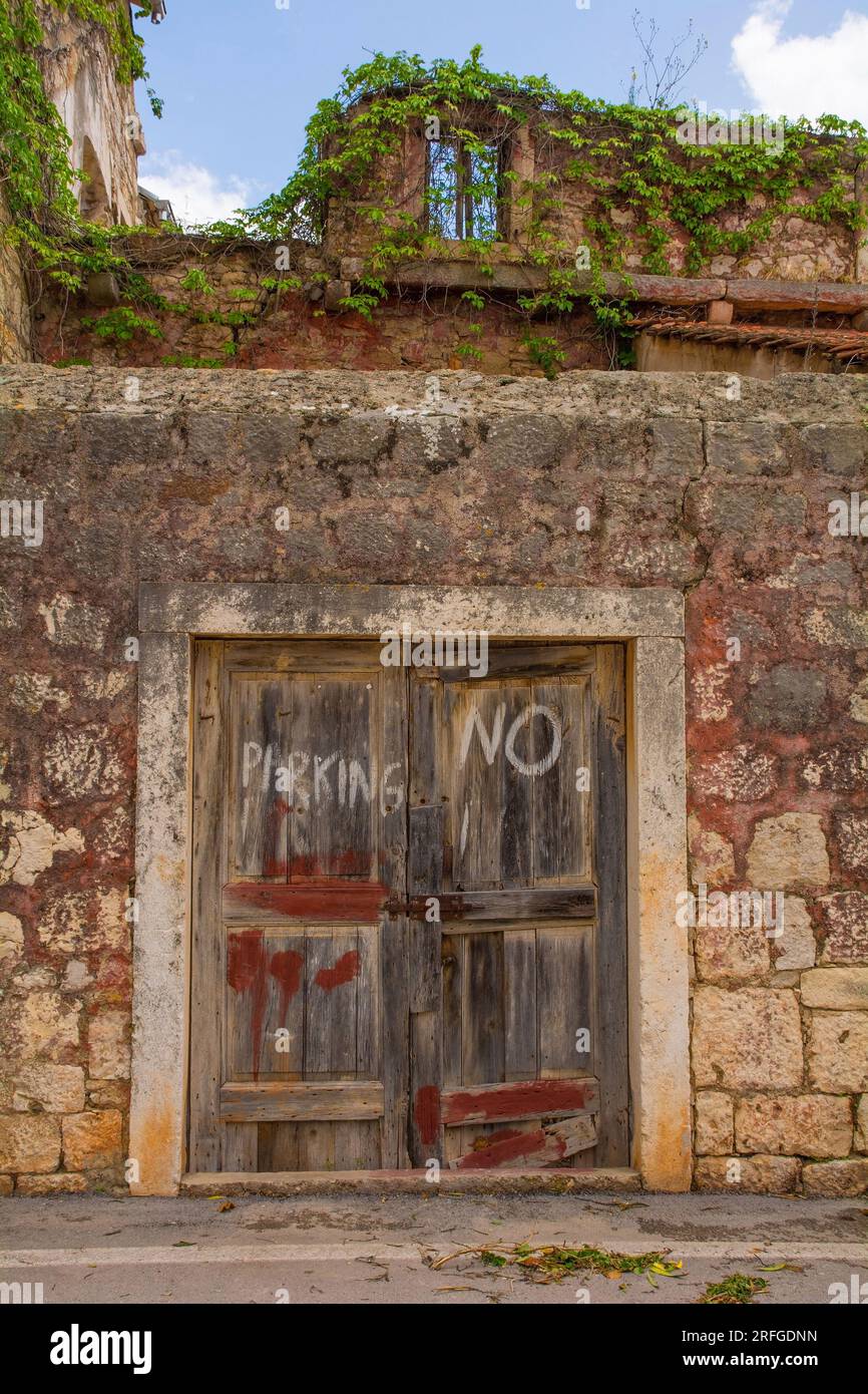 An old wooden door in an historic abandoned stone house in Milna ...