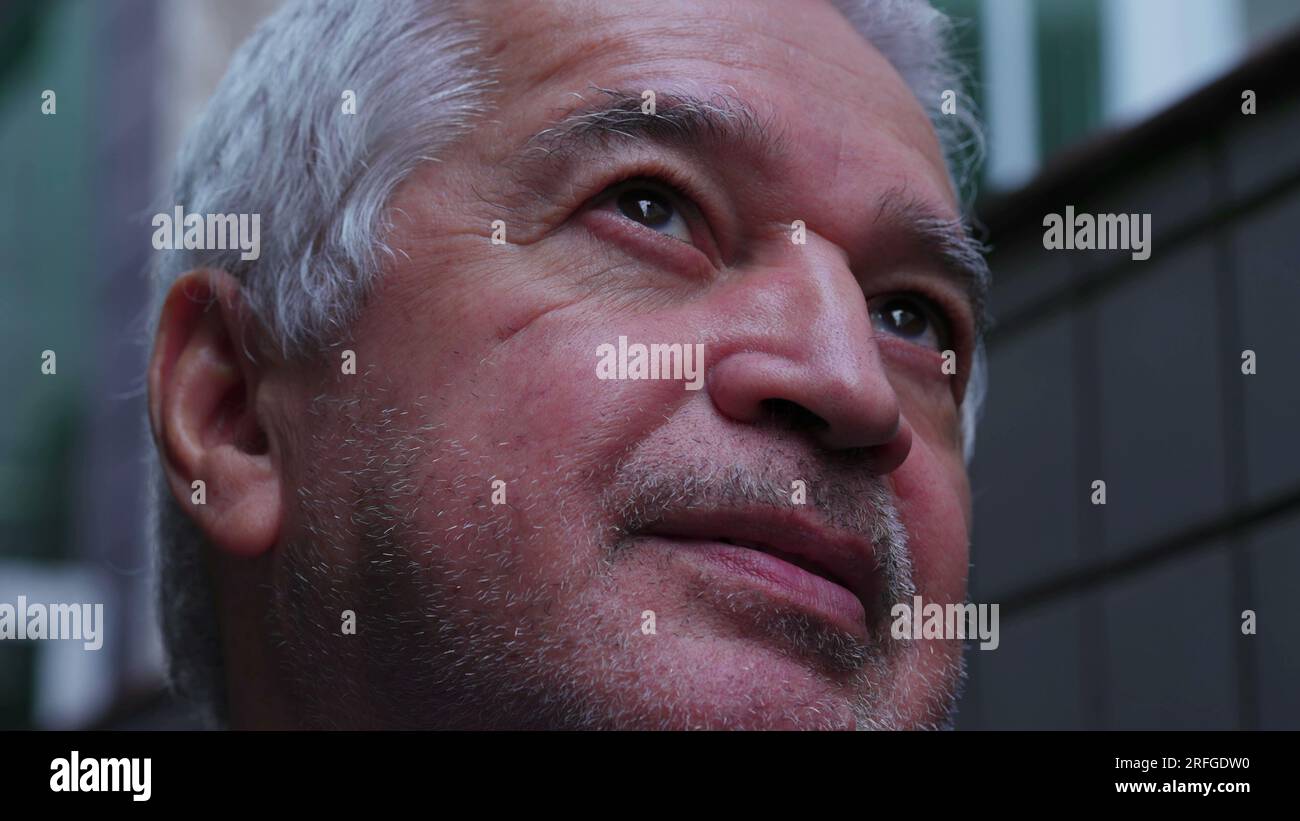 Close-up face of a senior man looking up at sky with HOPE and FAITH ...