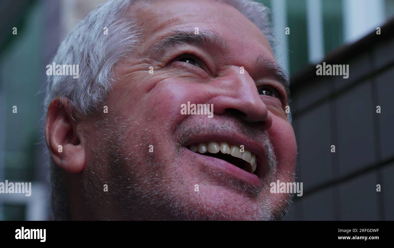 Close-up face of a senior man looking up at sky with HOPE and FAITH ...