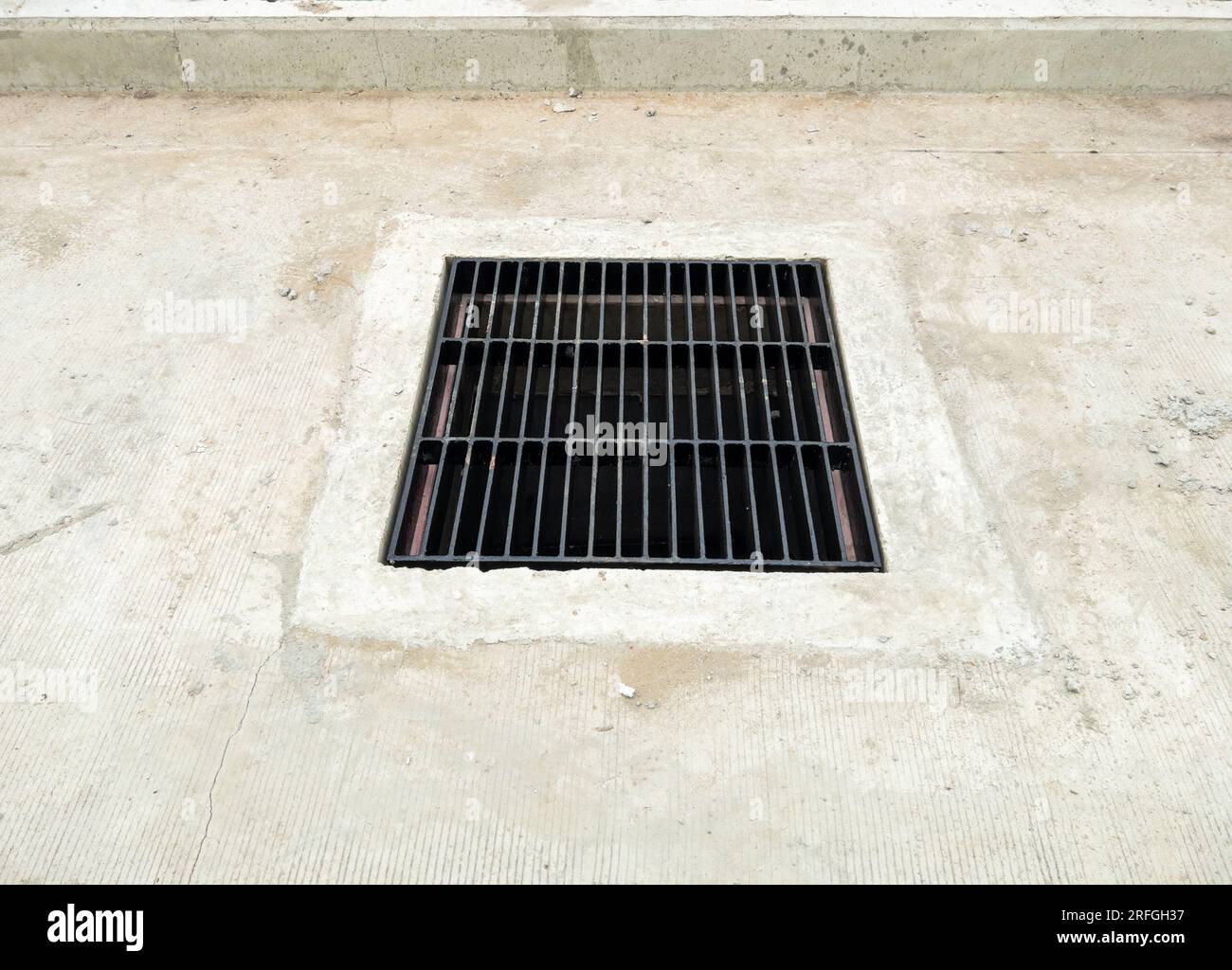 The drain cover grate on the concrete street for the drainage system ...