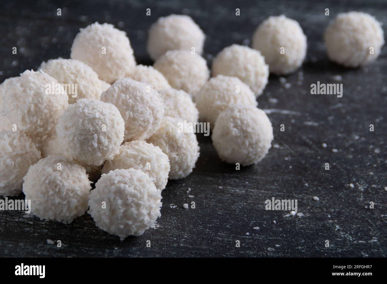 photo of coconut-flavored candy balls lying on a dark background close ...