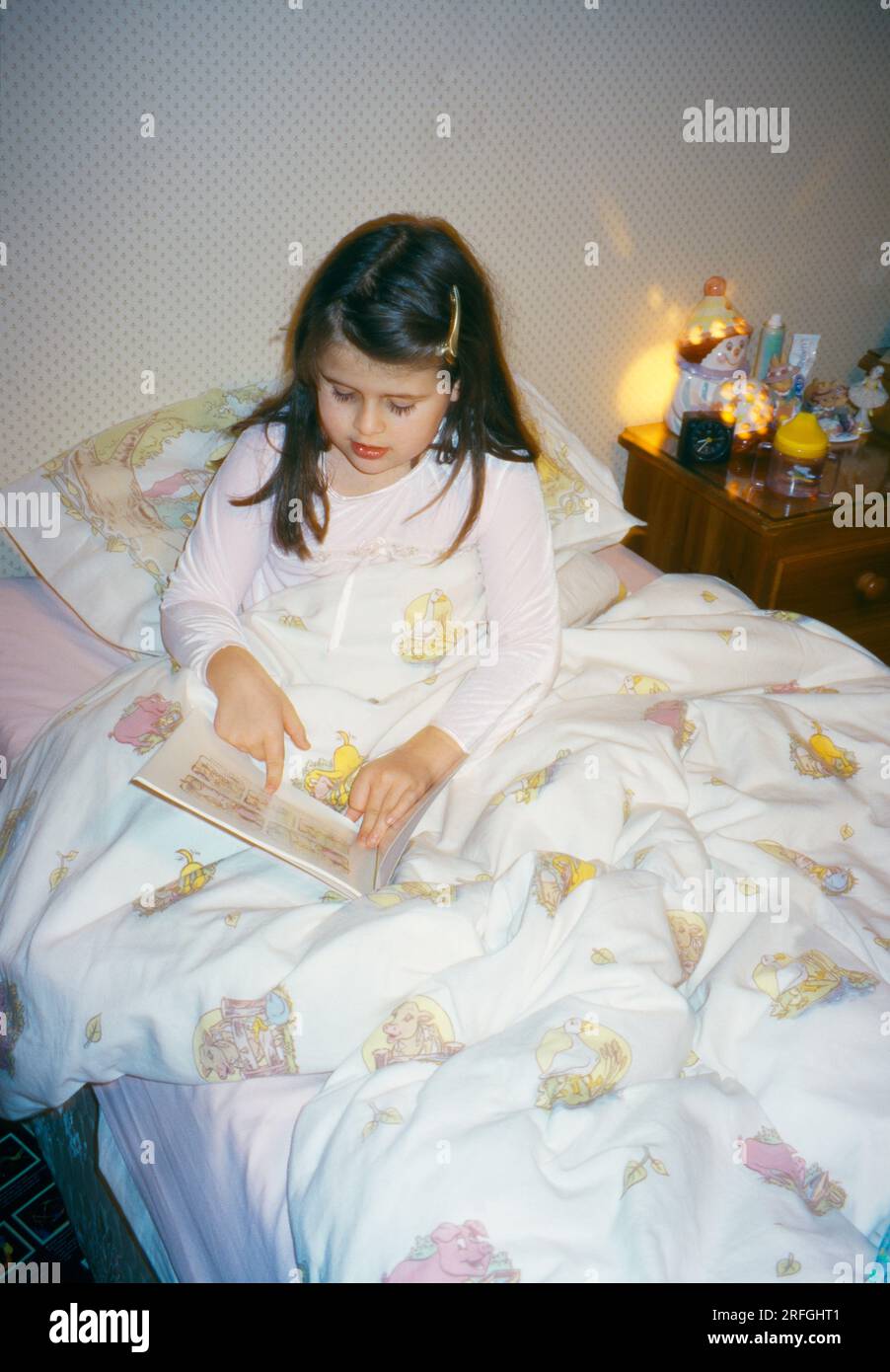 Child Reading Alone In Bed Wearing Pyjamas Surrey England Stock Photo ...