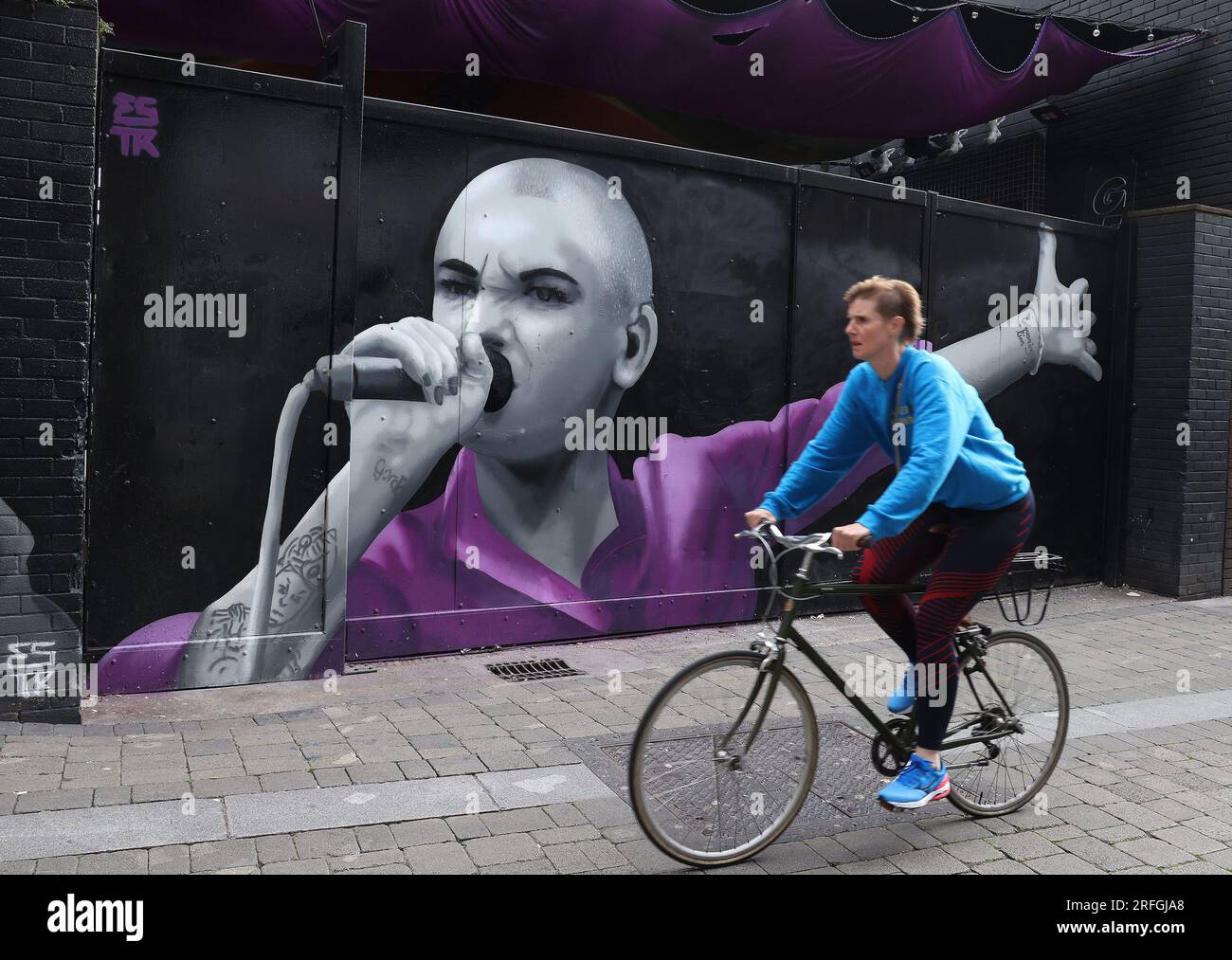 A cyclist passes a mural of Sinead O'Connor by Artist, Emmalene Blake ...