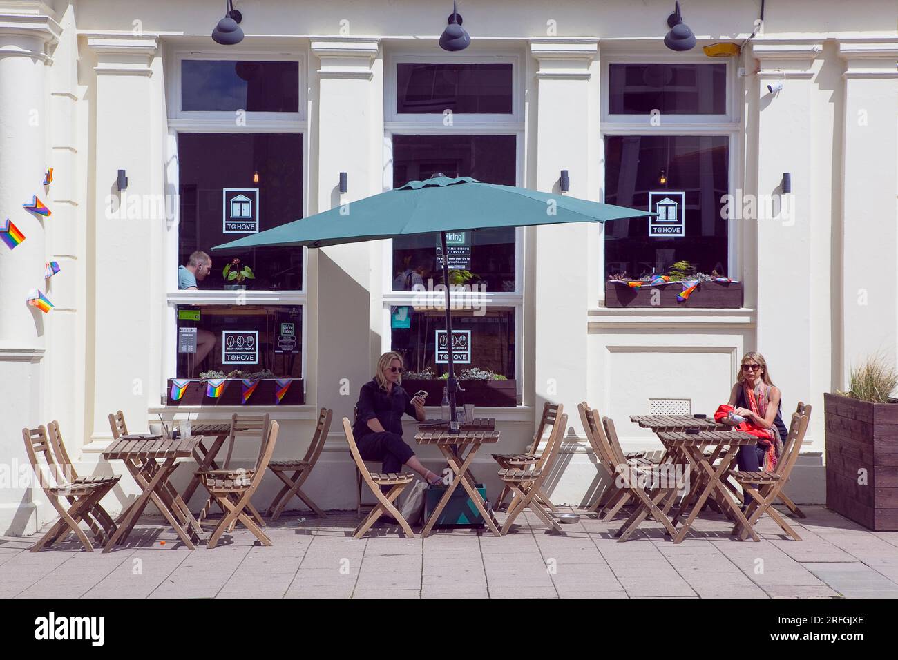 England, East Sussex, Brighton, Hove, Western Road, People sat outside ...