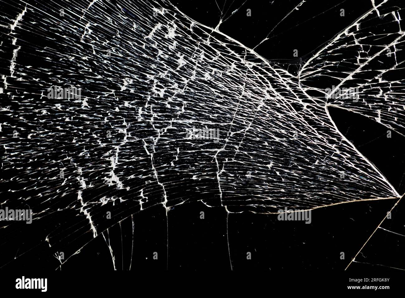 broken dirty glass with lots of damage and cracks on a black background ...