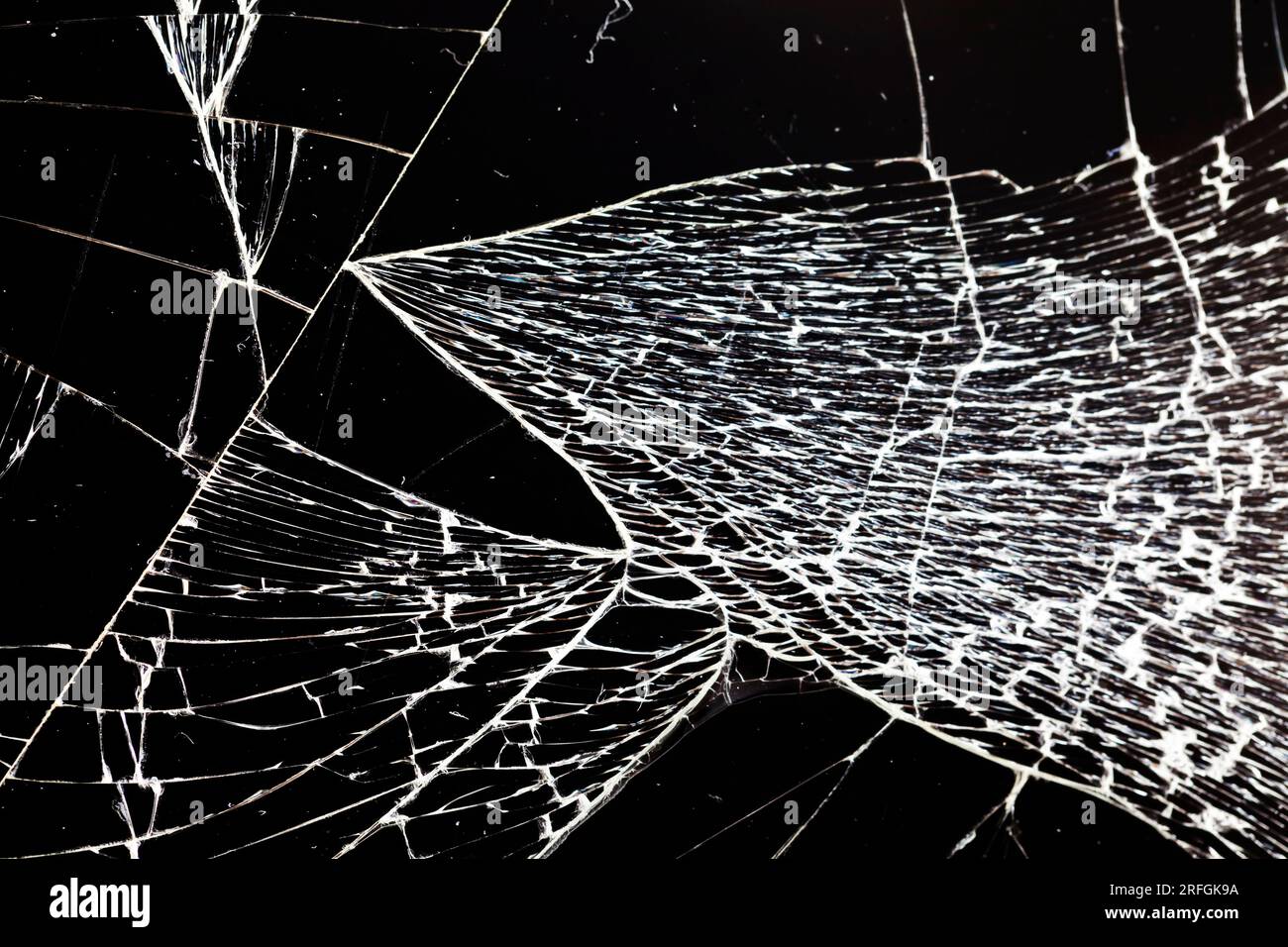 broken dirty glass with lots of damage and cracks on a black background ...