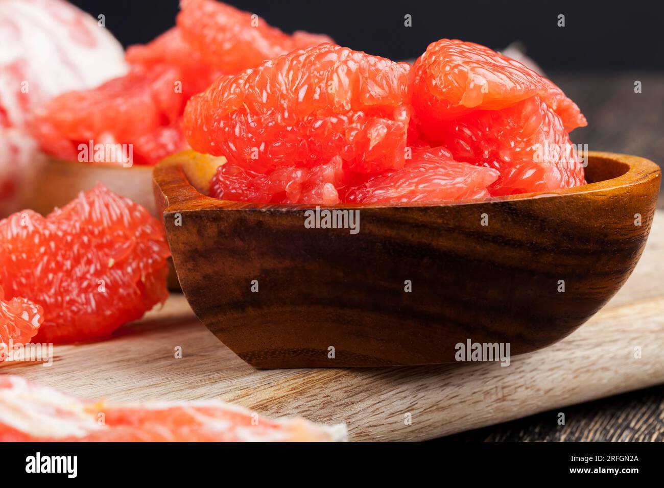 peeled pink grapefruit split into pieces while cooking, ready to eat ...