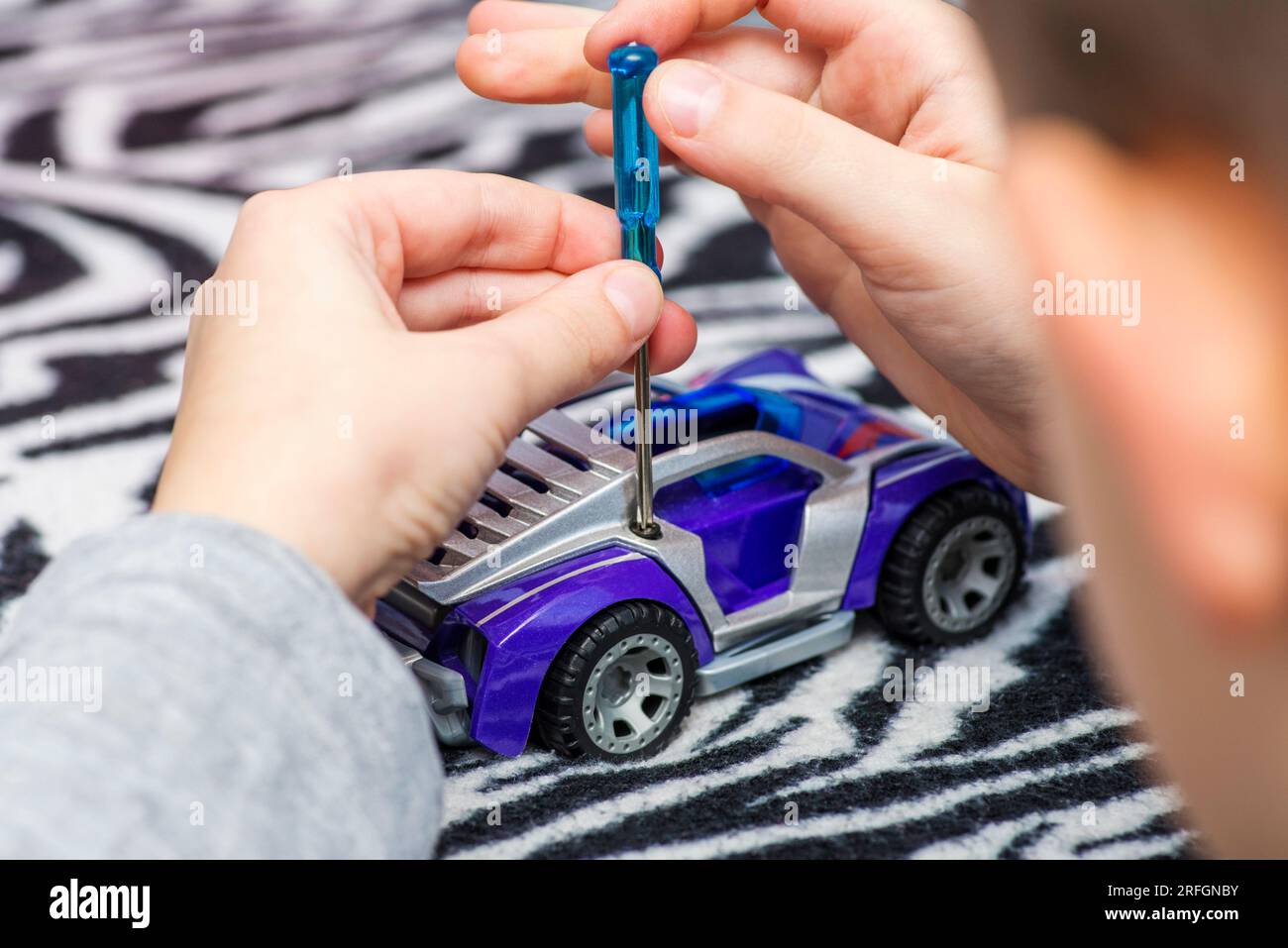 Small child boy holding screwdriver, fixing broken toy Stock Photo - Alamy