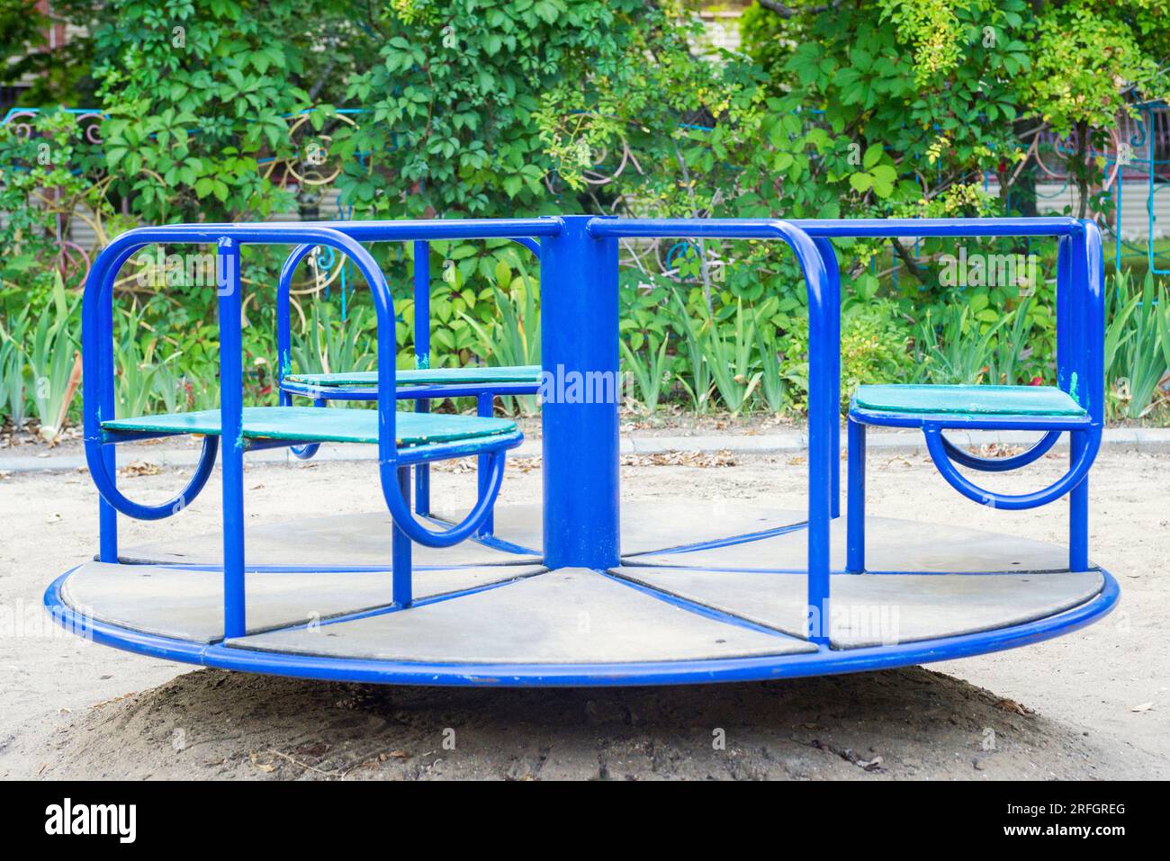 Empty childrens metal carousel on outdoor playground Stock Photo - Alamy