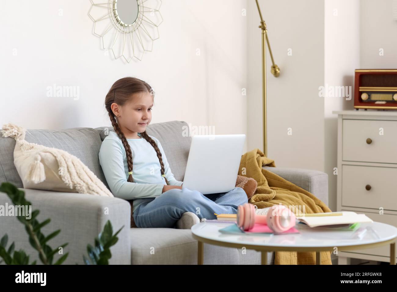Little girl with laptop studying computer sciences online at home Stock ...