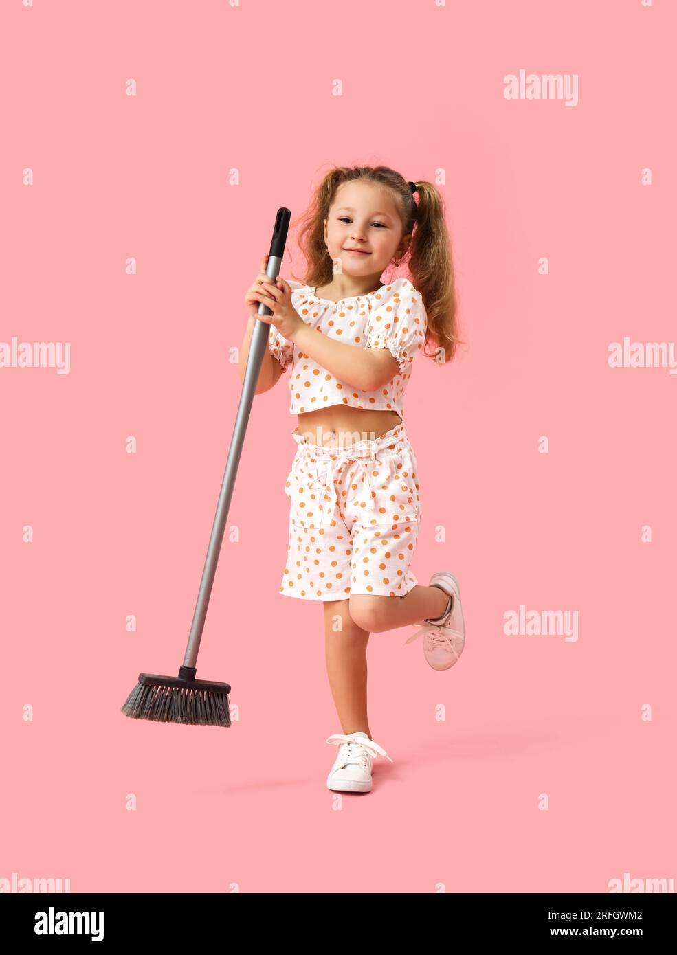 Cute little girl with broom on pink background Stock Photo - Alamy