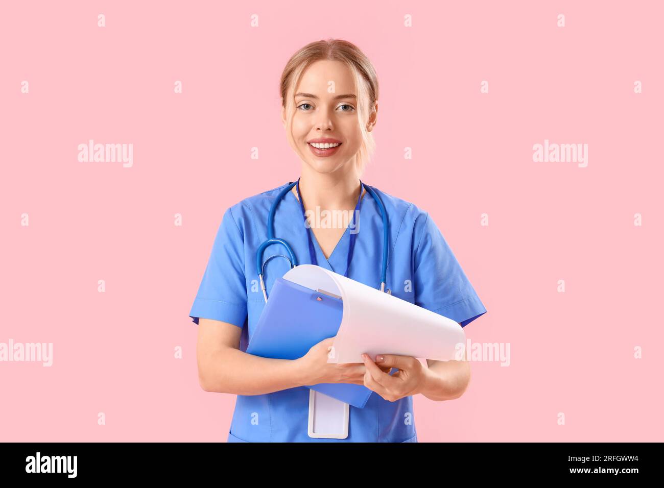 Female medical intern with clipboard on pink background Stock Photo - Alamy