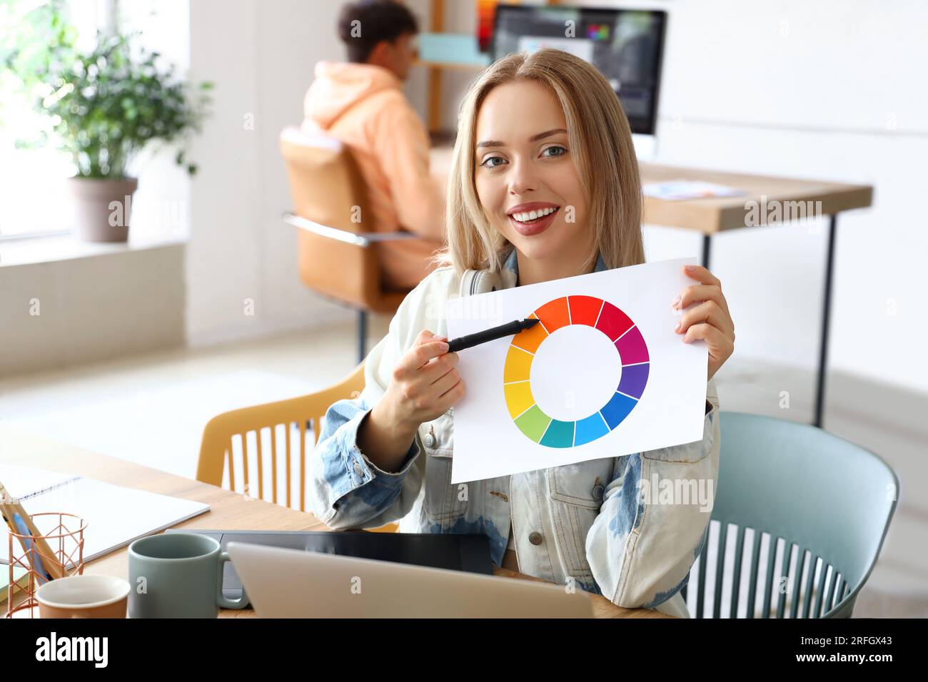 Female graphic designer working with color palette at table in office ...