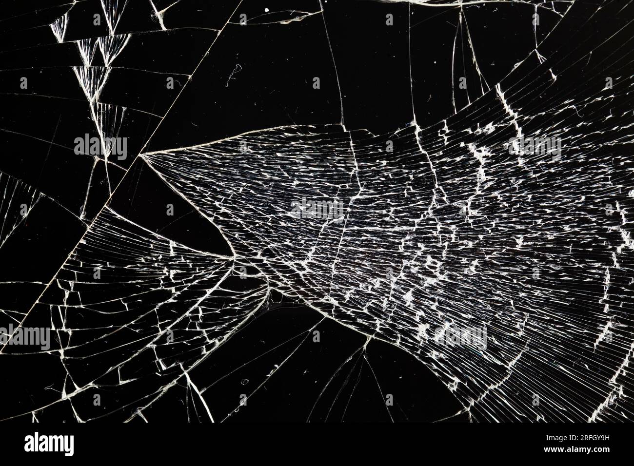 broken dirty glass with lots of damage and cracks on a black background ...