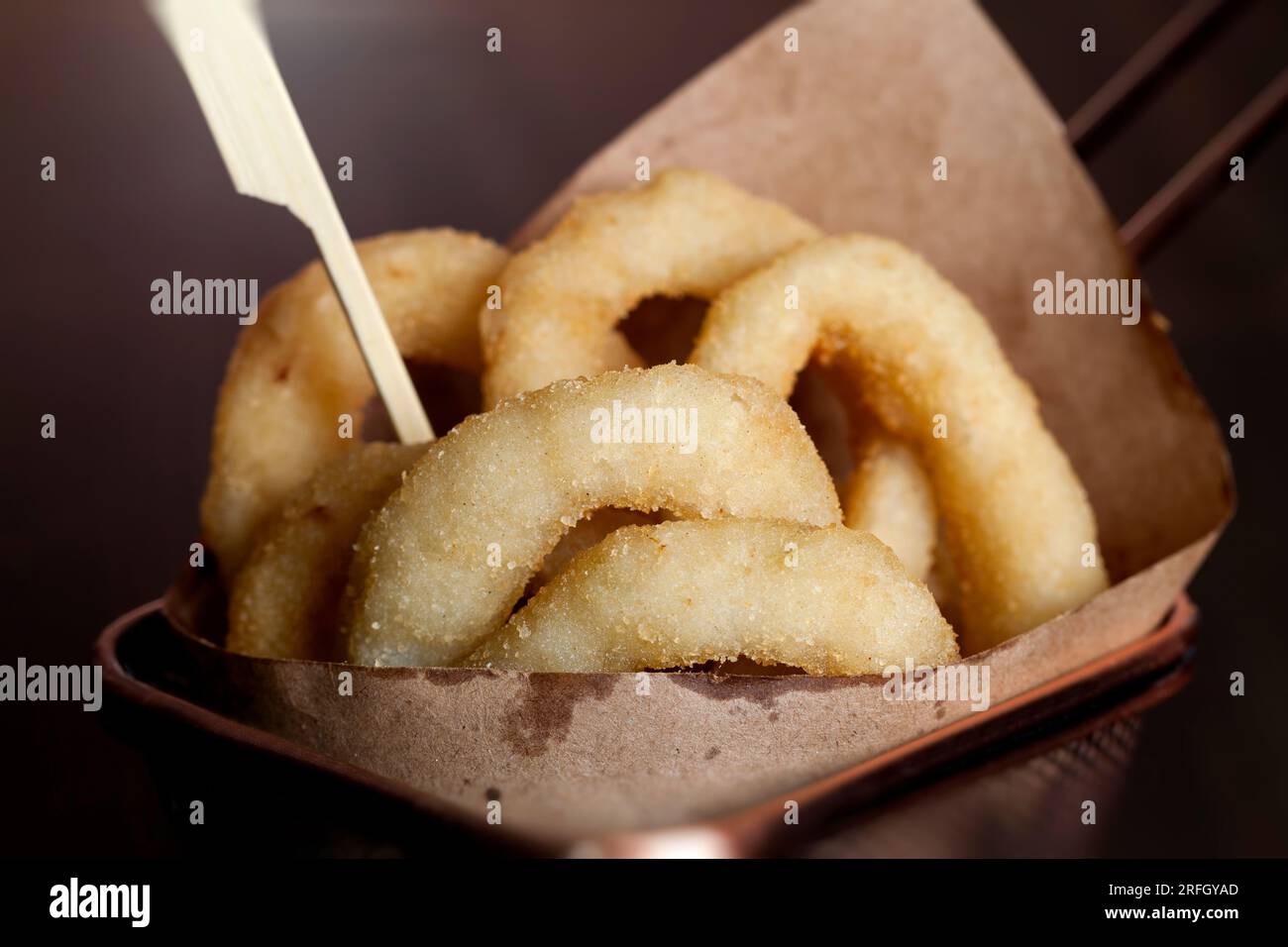 sliced and fried onion rings in paper packaging in a cafe, food in a ...