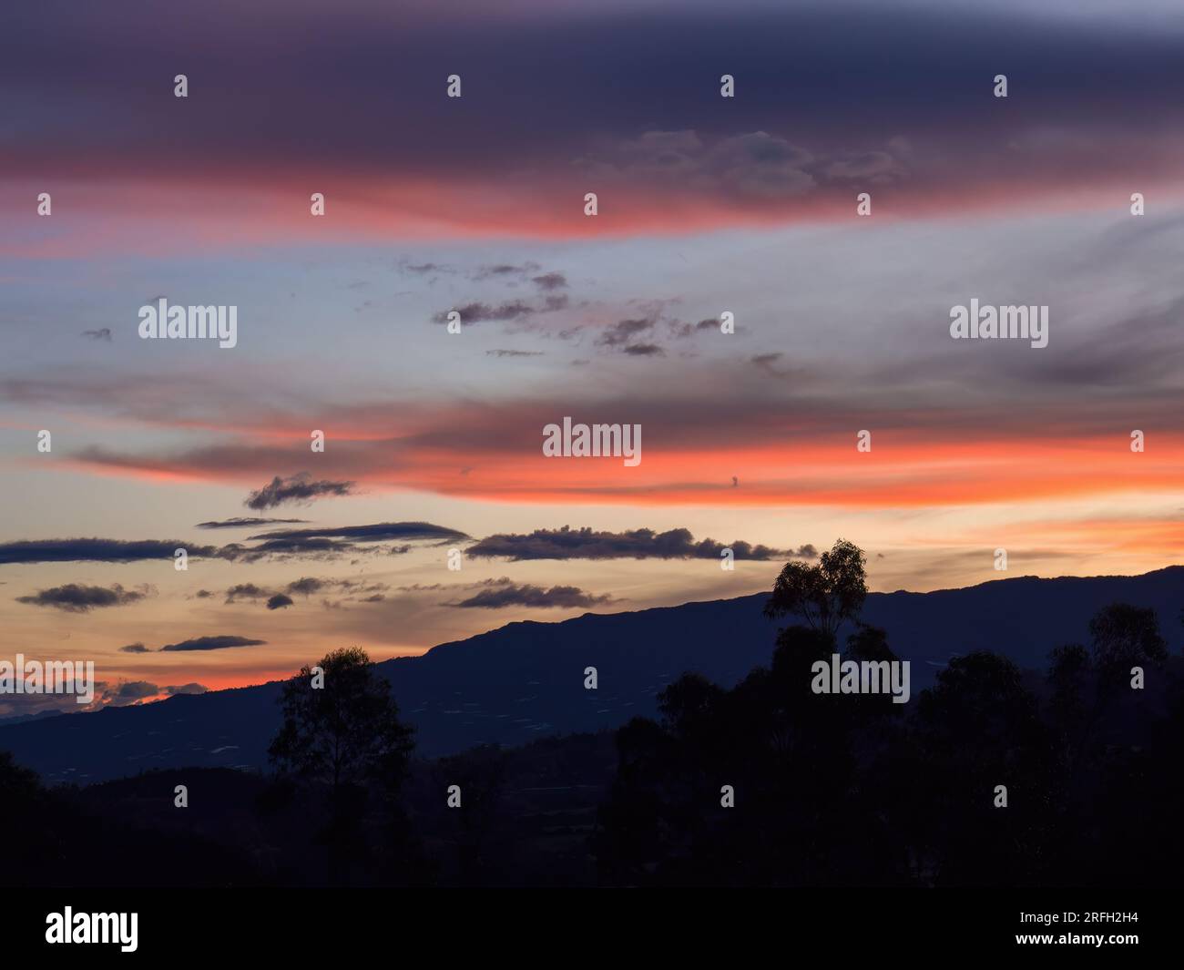 The beautiful colors of a sunset over the farmlands and mountains of ...