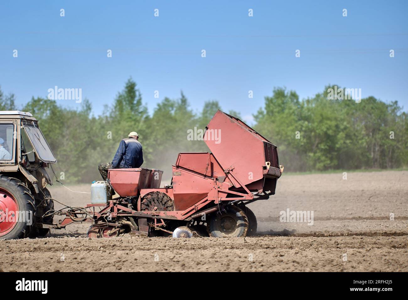 Farmer field with potato planter during spring planting Stock Photo - Alamy
