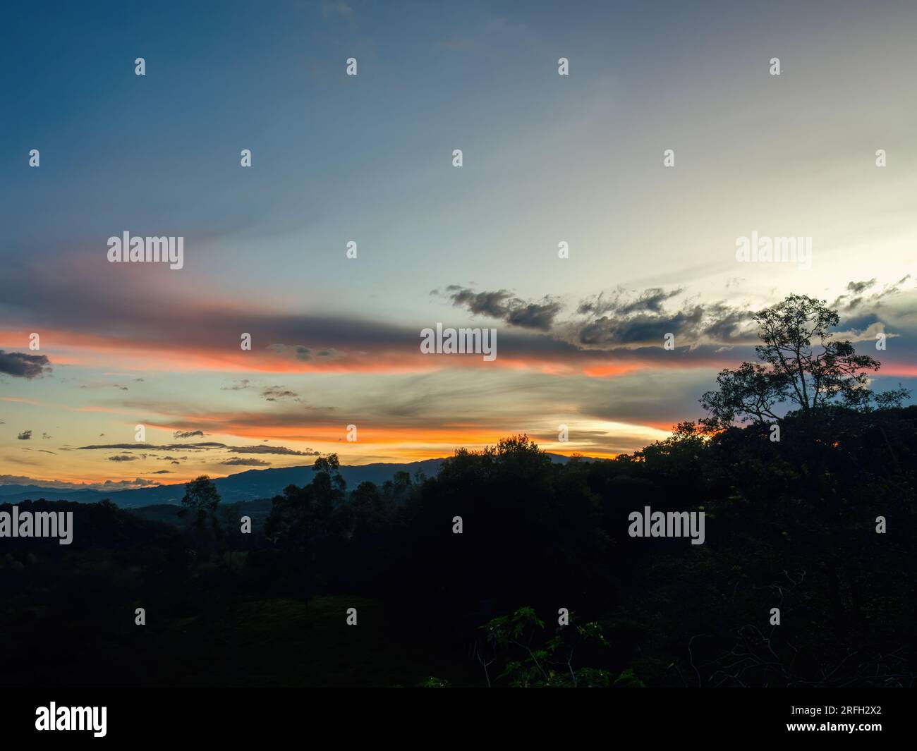 The beautiful colors of a sunset over the farmlands and mountains of ...