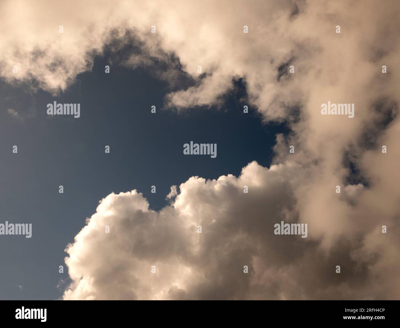 Fluffy clouds over sunset sky. Fluffy cumulus cloud shape photo, gloomy ...