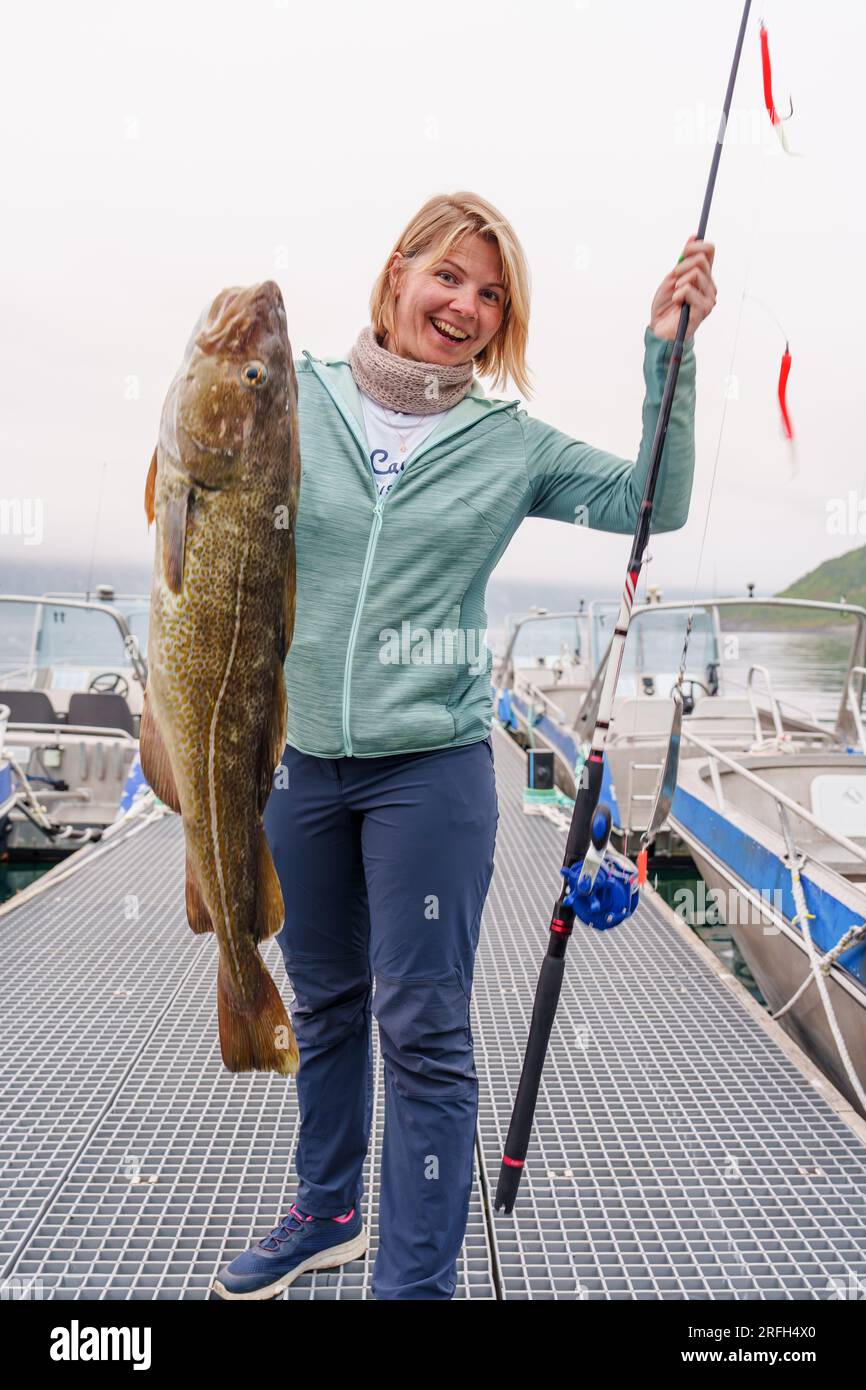 Happy Fisherwoman holding big arctic cod. Norway happy fishing. Woman ...