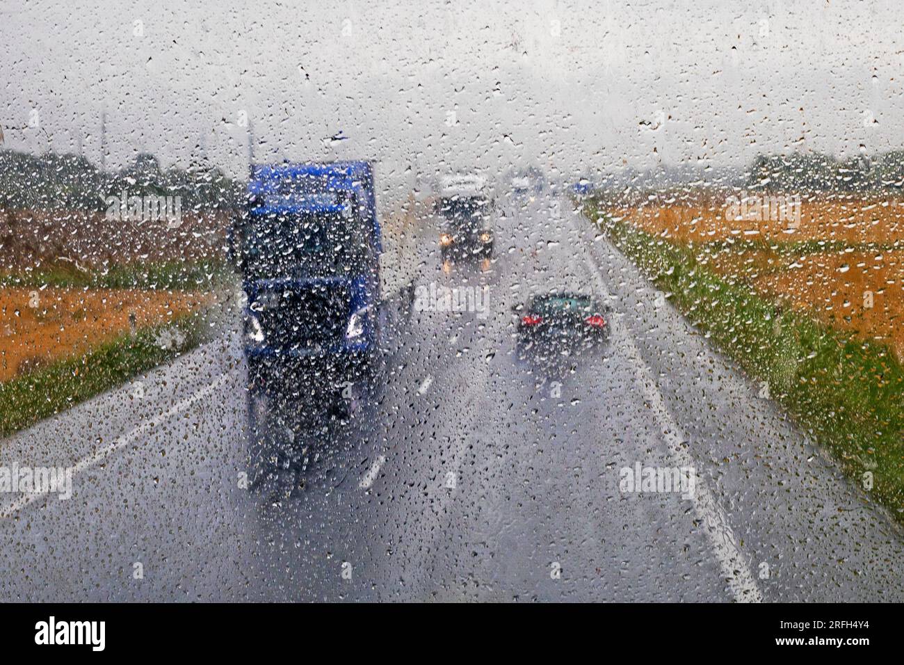 trucks drive along the main slippery road during the rain. Bad weather ...