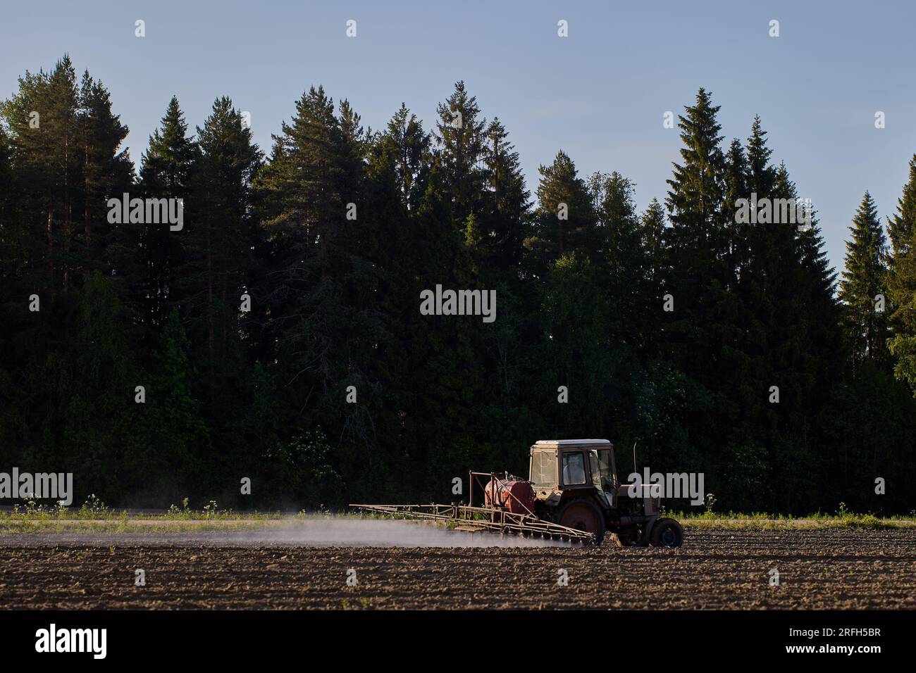 Agricultural farm tractor with crop sprayer attached to it Stock Photo ...