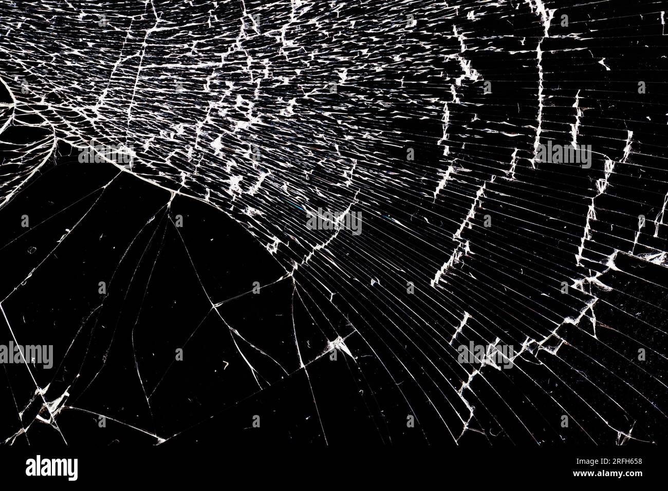 broken dirty glass with lots of damage and cracks on a black background ...