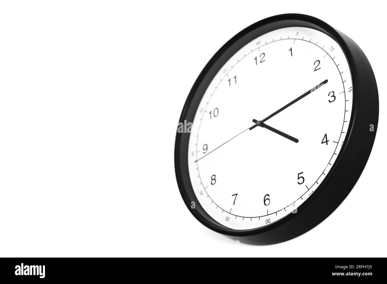 Part of analogue plain wall clock on white wall background. Four o ...