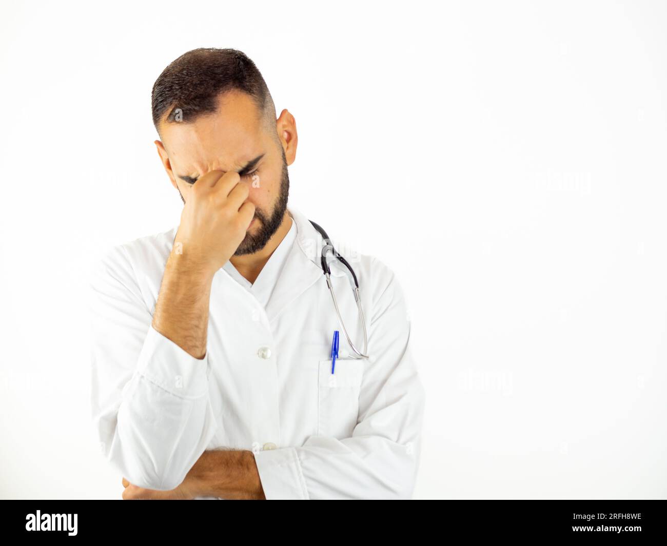 Young stressed male doctor having a headache. Isolated on white ...