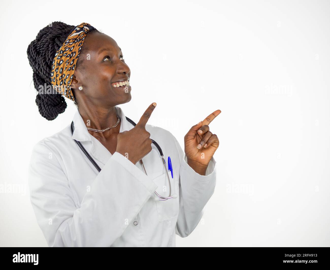 Young female doctor pointing right while smiling. Isolated on white ...