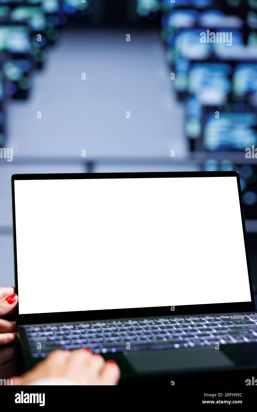Close up shot of mock up laptop used by experienced IT developer in data center using server ...