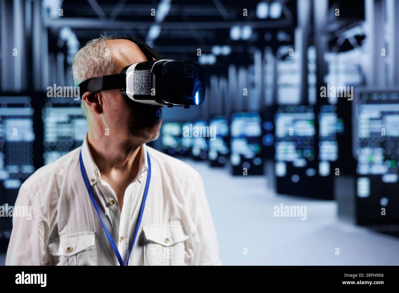 Aged computer scientist immersed in virtual reality at data center ...
