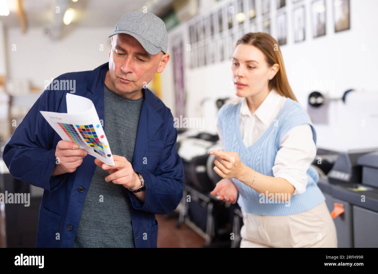 Service engineer and office worker checking color chart test page ...