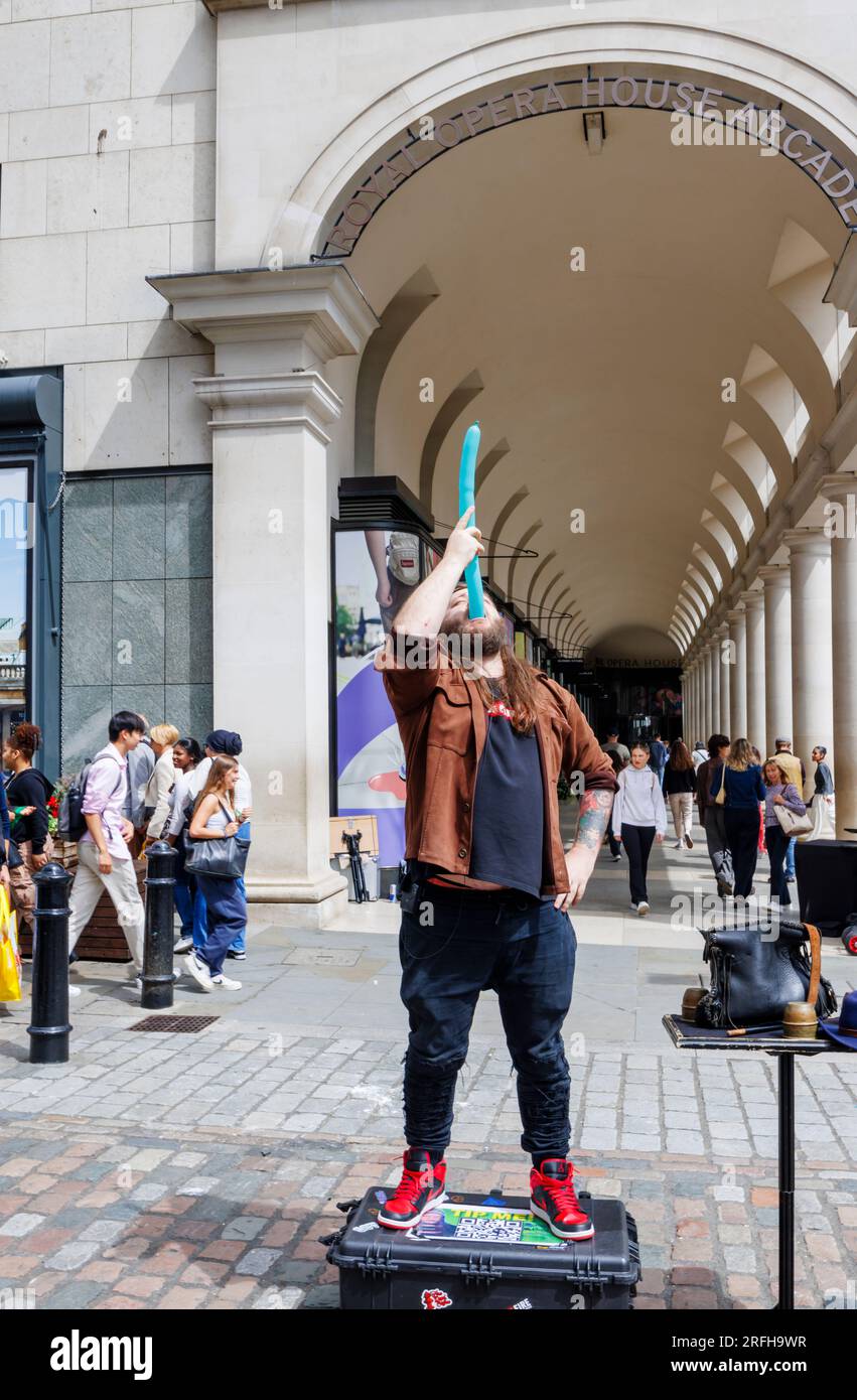 Australian street magician Jason Maher swallows a balloon as he ...