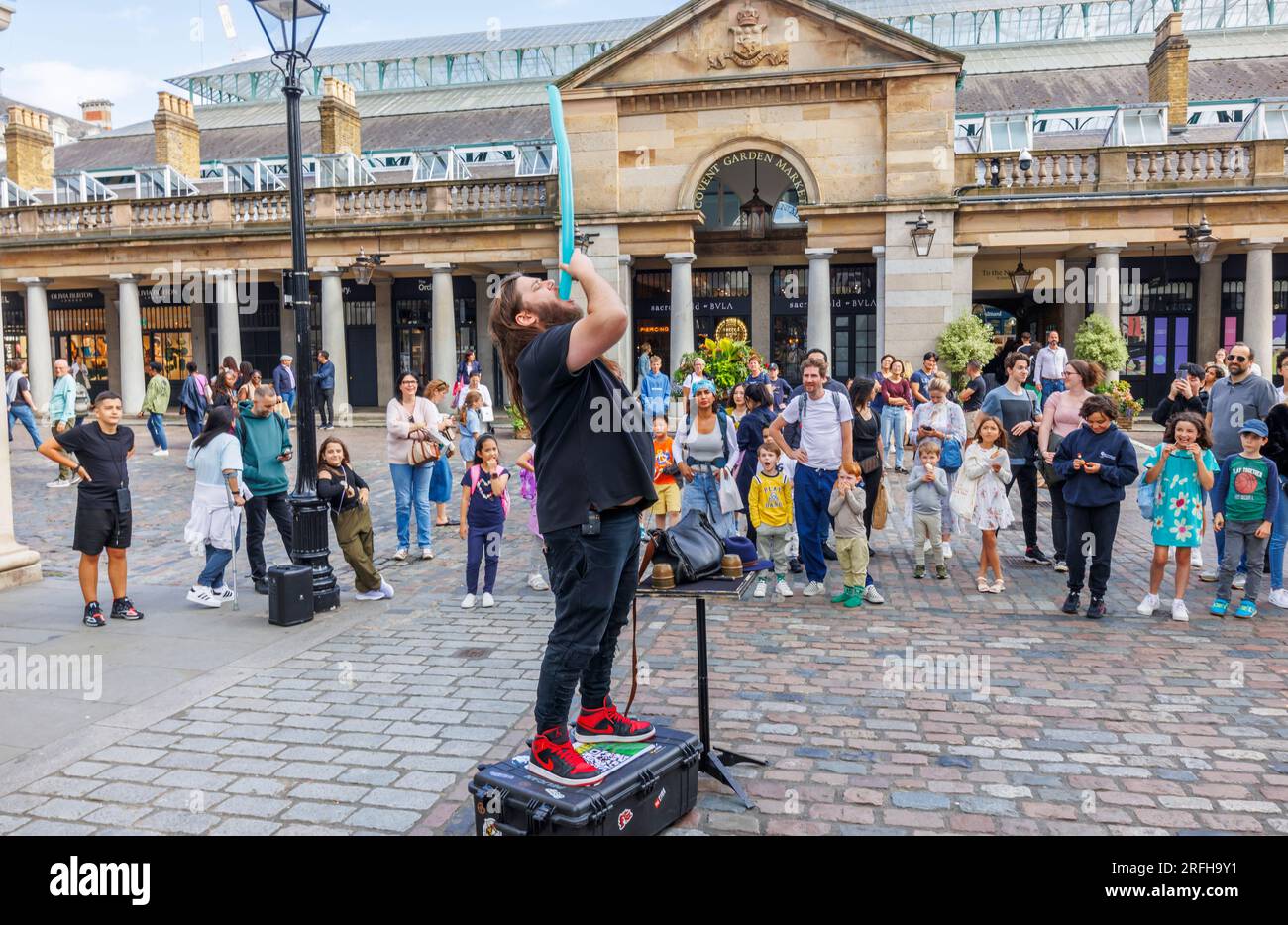 Australian street magician Jason Maher swallowing a balloon performs ...