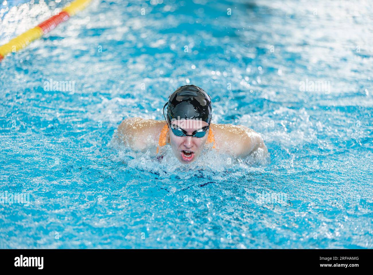Female competitive swimmer moving through the water performing the ...